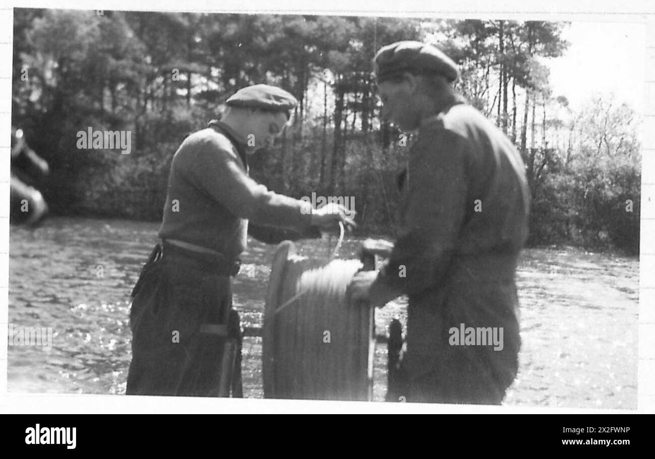 British Army personnel lay out communications cable from a Weasel ...