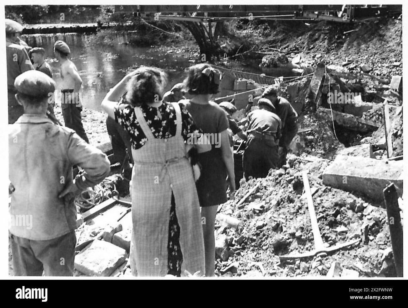 SAPPERS BRIDGE THE RIVER NOIREAU - The villagers look on as the span ...