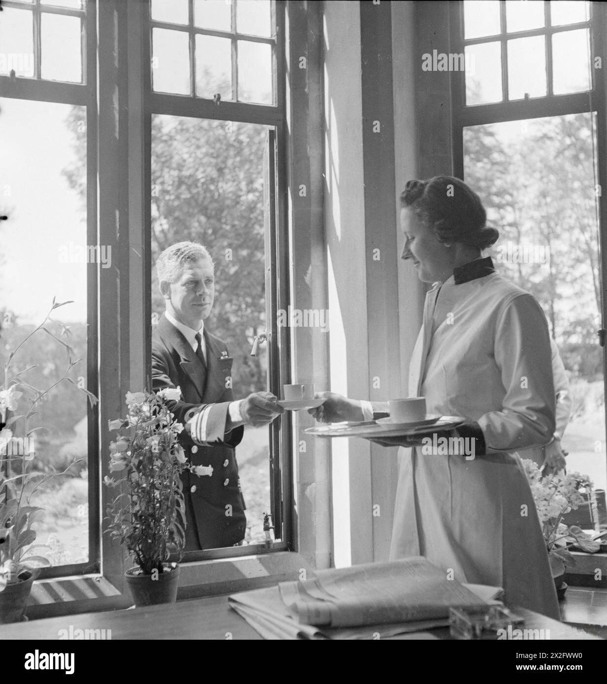 A Wren serves coffee to the First Lieutenant Commander in the wardroom ...