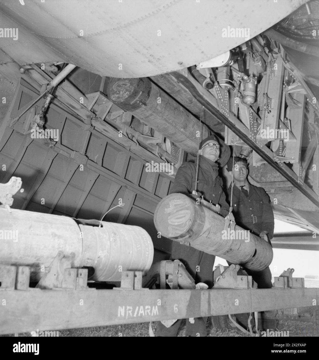250-pound depth charges are hoisted into the bomb bay of a No. 220 ...