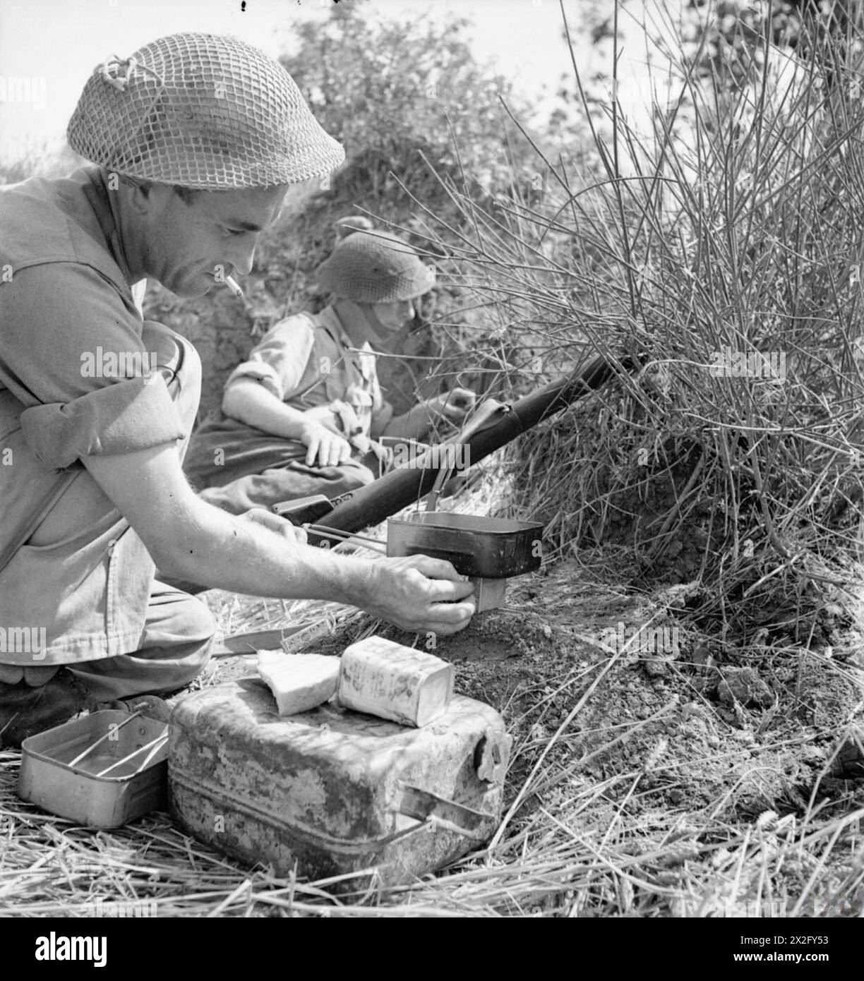 An infantryman of the British Army heats a mess tin of water in a ...