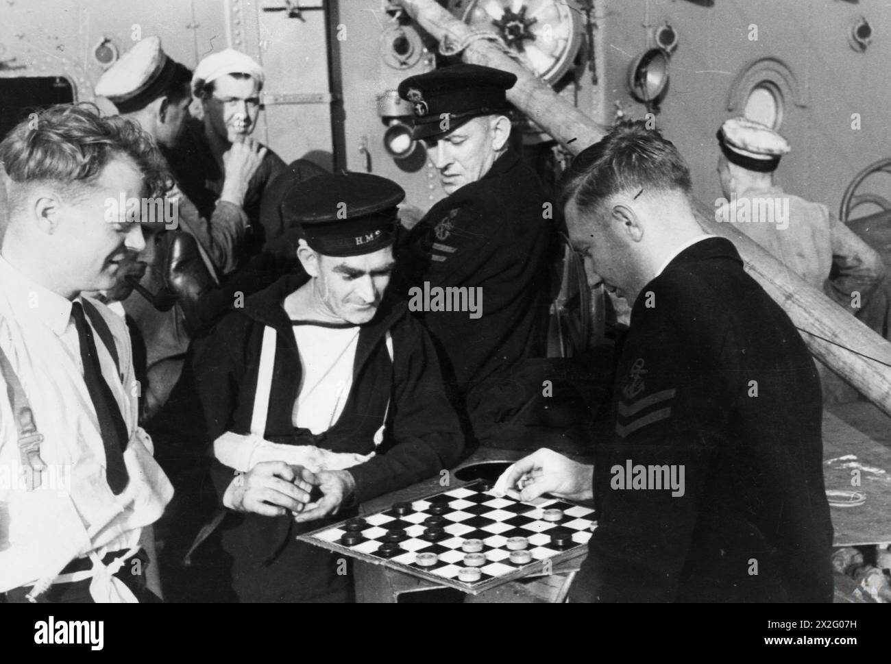 Crew members on HMS Kelvin play draughts on the mess deck of the ...