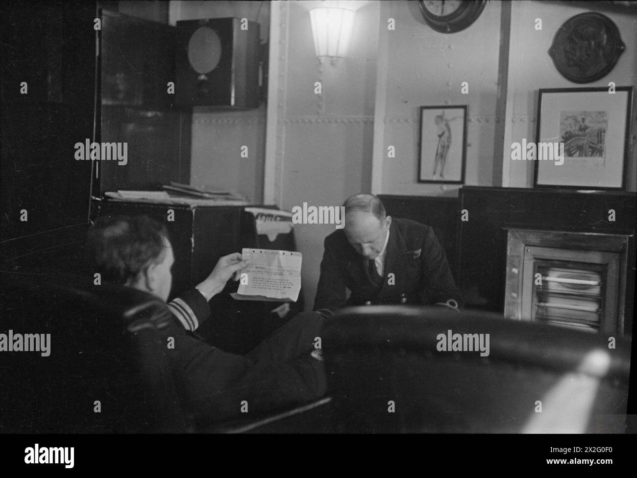 Officers gather in the Ward Room aboard HMS Kelvin at sea in April 1941 ...