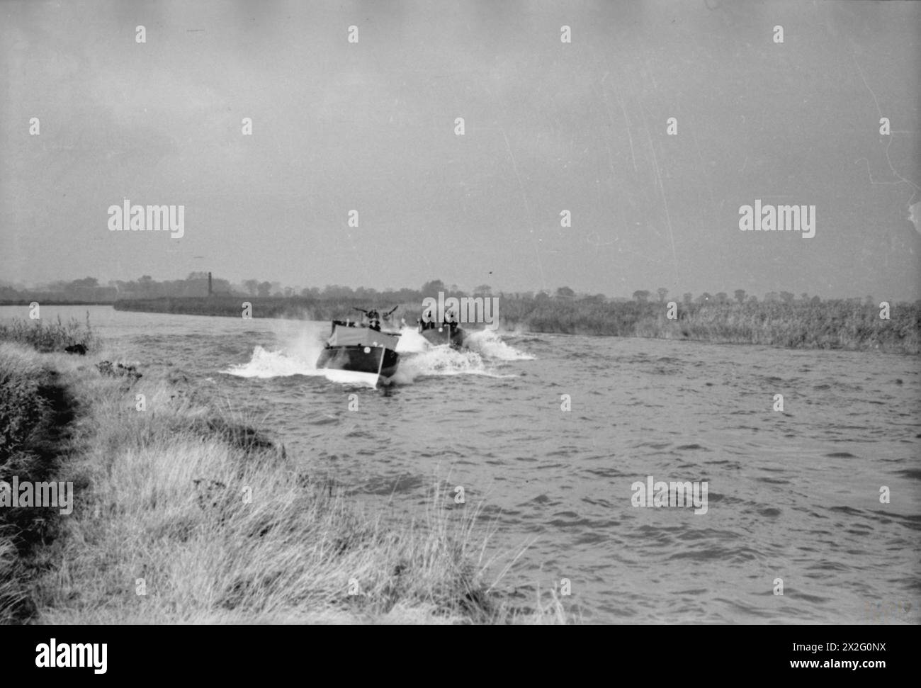Boats of the Norfolk Broads flotilla maneuver at speed on the river ...
