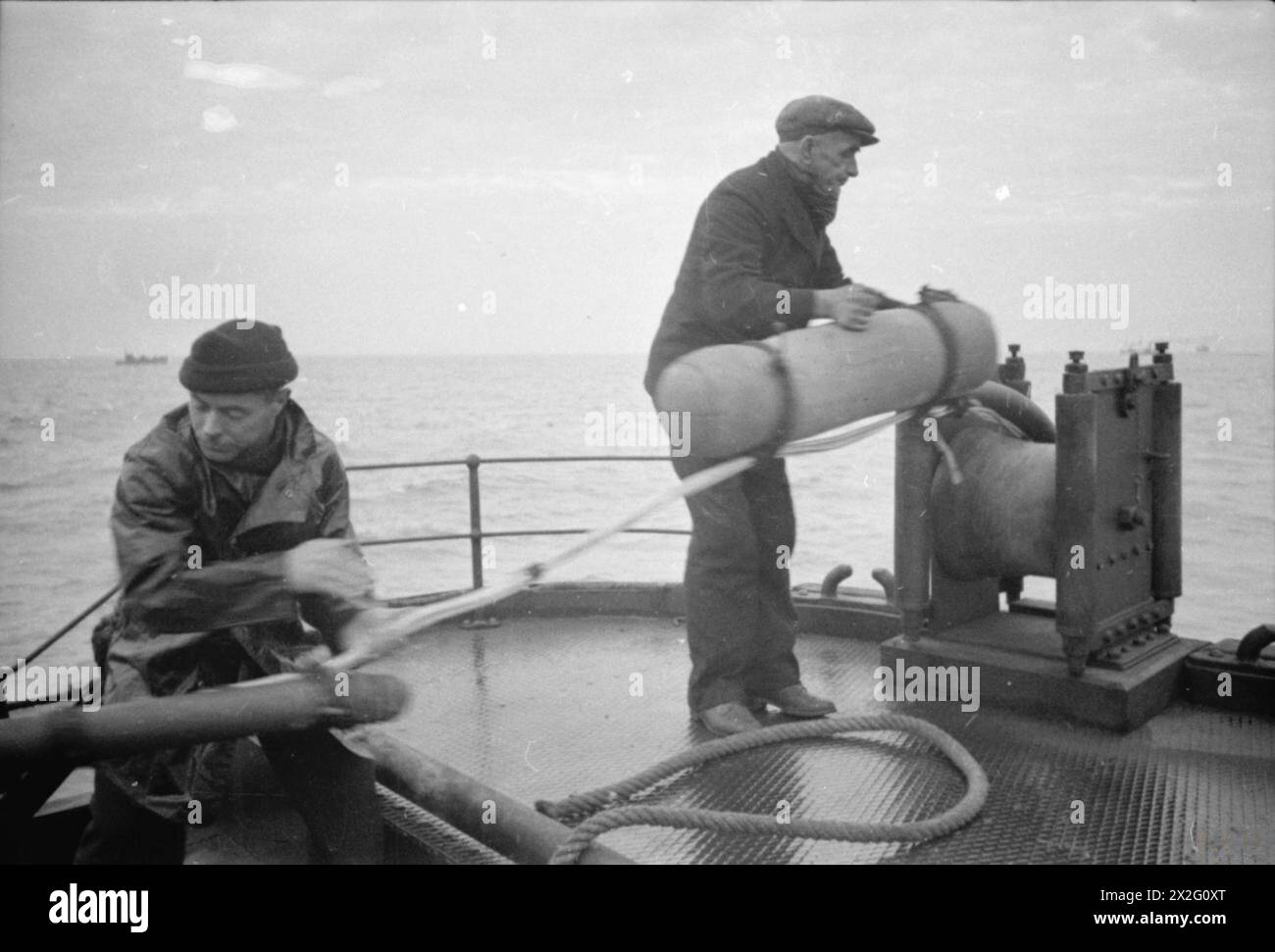 On board the minesweeper HMT Cayrian in 1940, sailors operate a ...