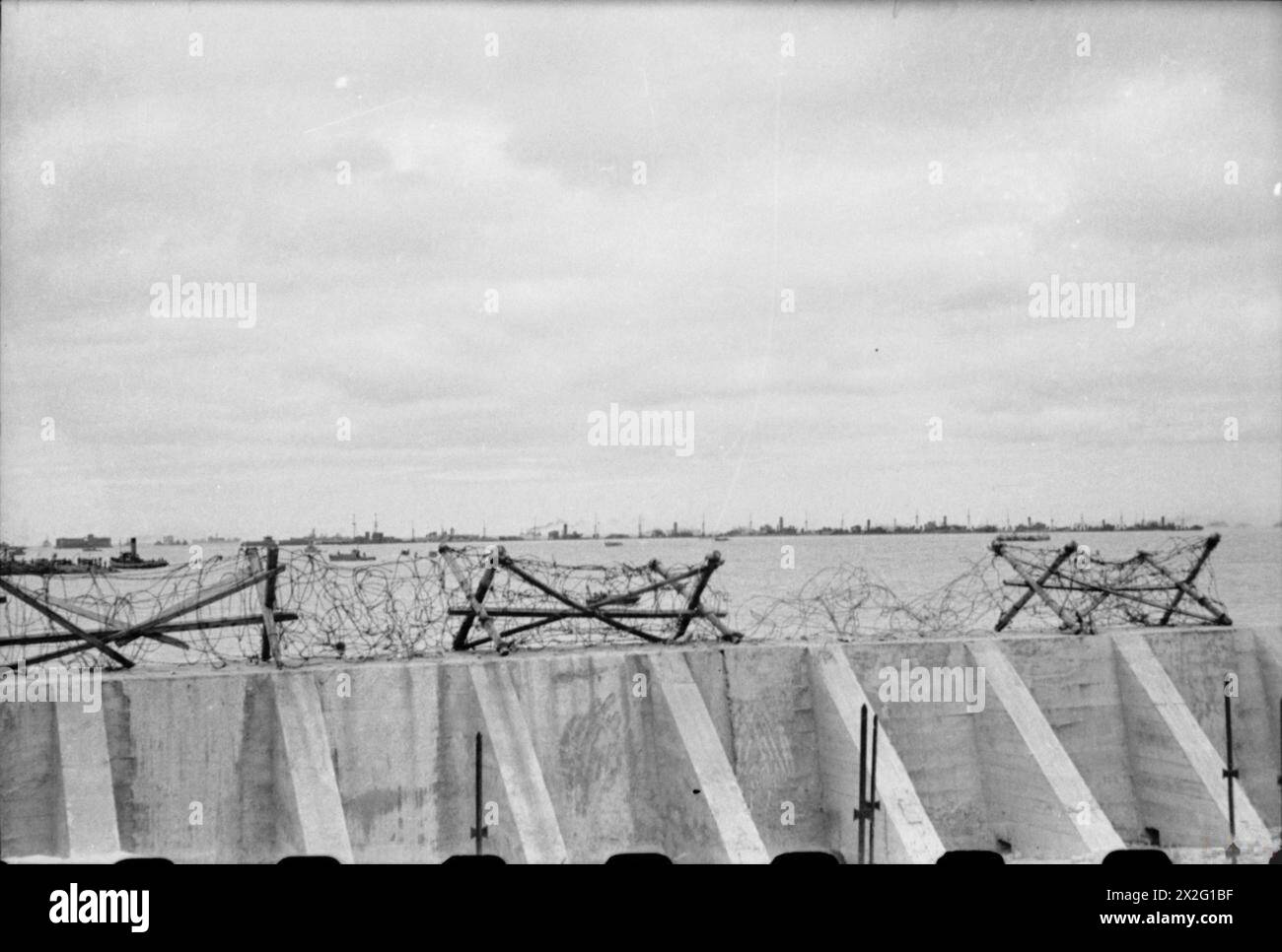 The 'West Wall' at Arromanches, part of the Mulberry Harbour, with sunk ...