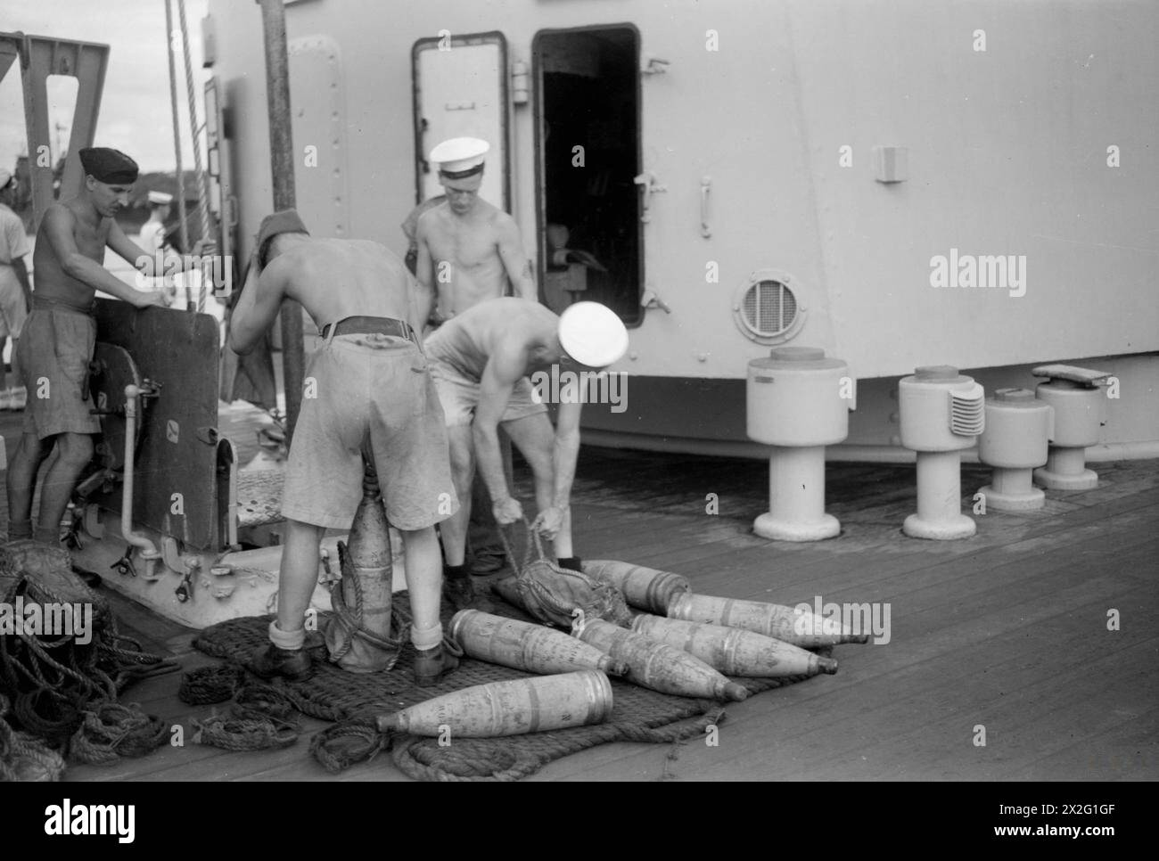 Shells are lowered into the shellroom aboard the Eastern Fleet cruiser ...