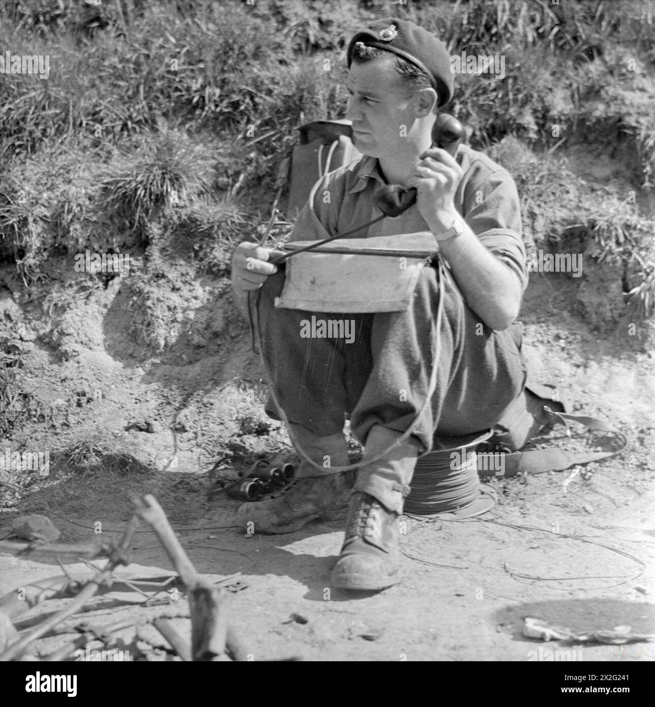 A Sergeant uses a field telephone to relay fire orders to mortarmen of ...