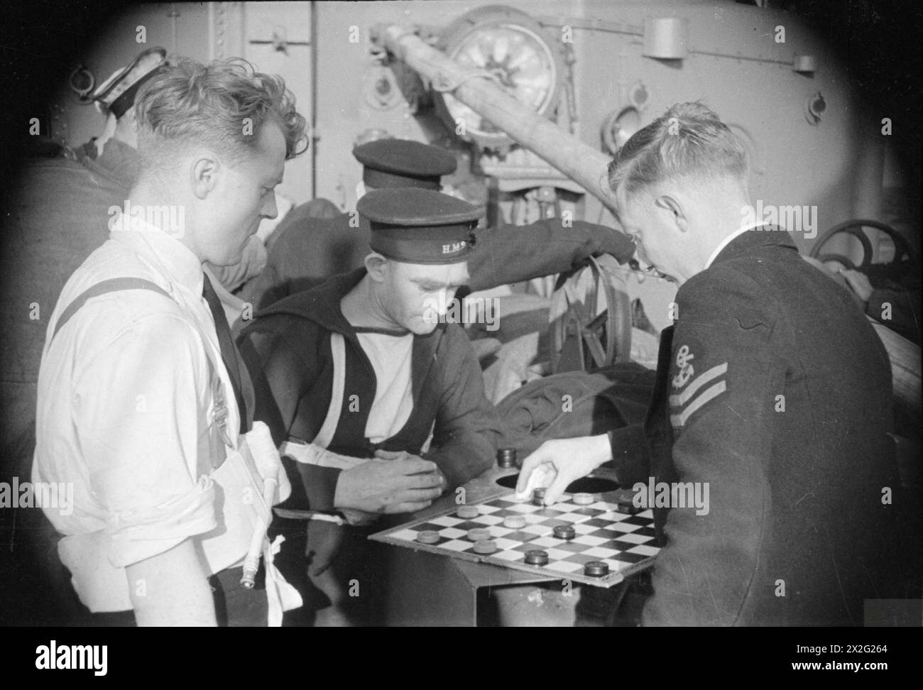 Sailors aboard HMS Kelvin in 1940 playing draughts on the mess deck ...