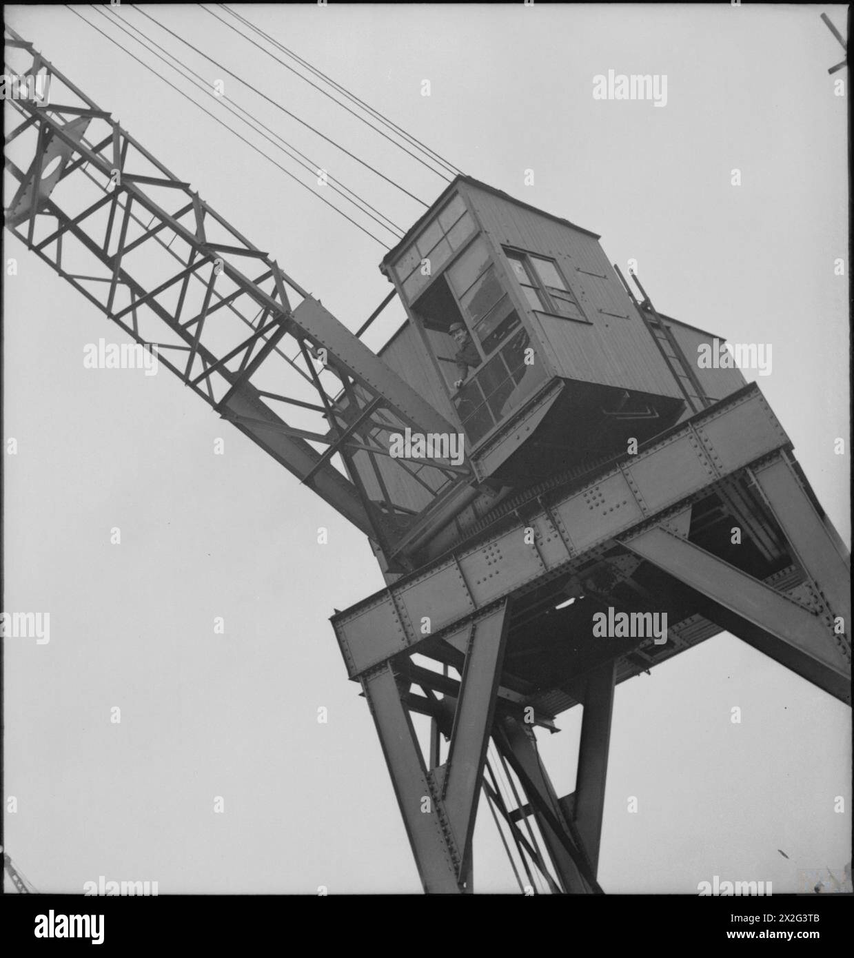 WAR INDUSTRY, UK, 1942 - A woman crane driver looks down from the ...