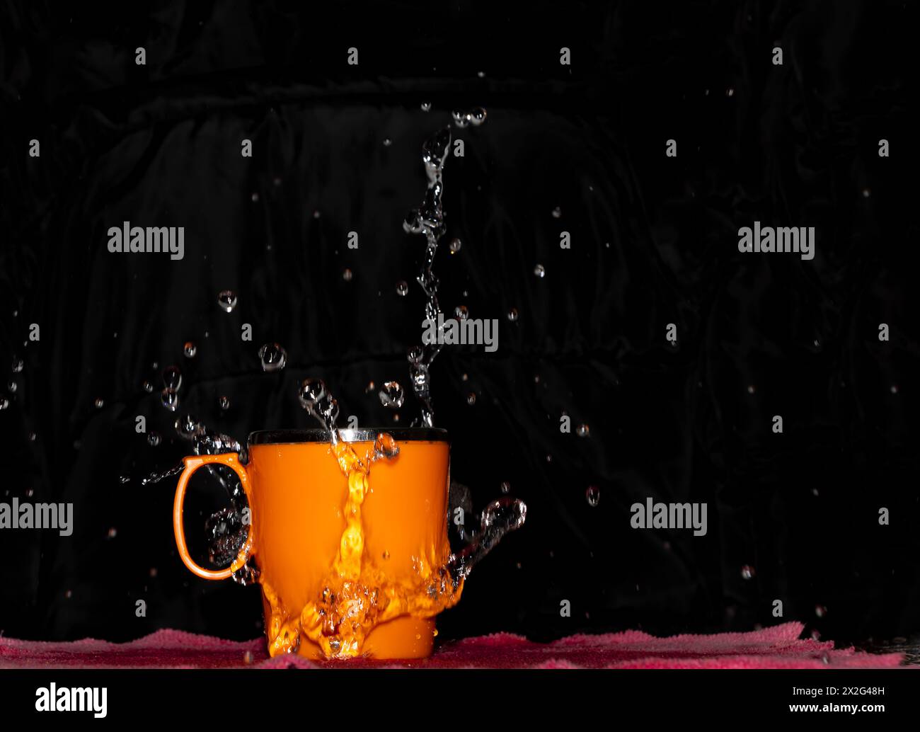 Closeup Image Of Splashing Water From Orange Color Cup Stock Photo - Alamy
