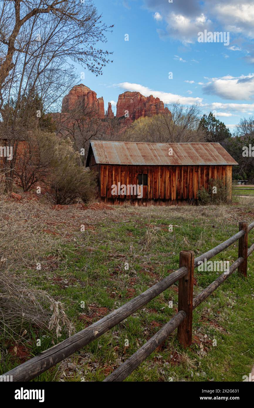 Cathedral Rock sandstone formations tower over a rustic barn at the ...