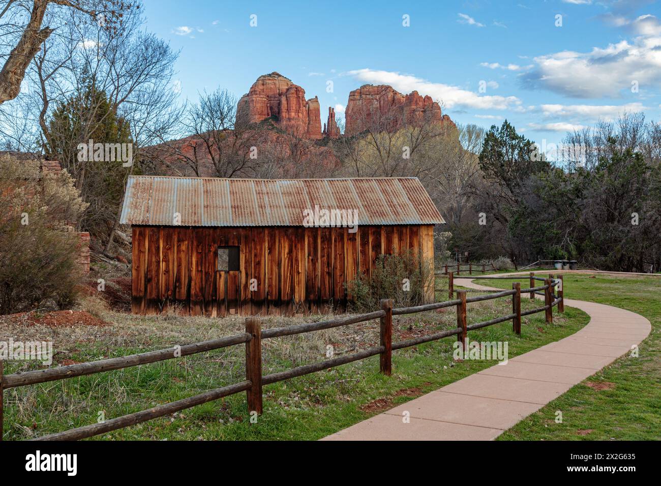 Cathedral Rock sandstone formations tower over a rustic barn at the ...