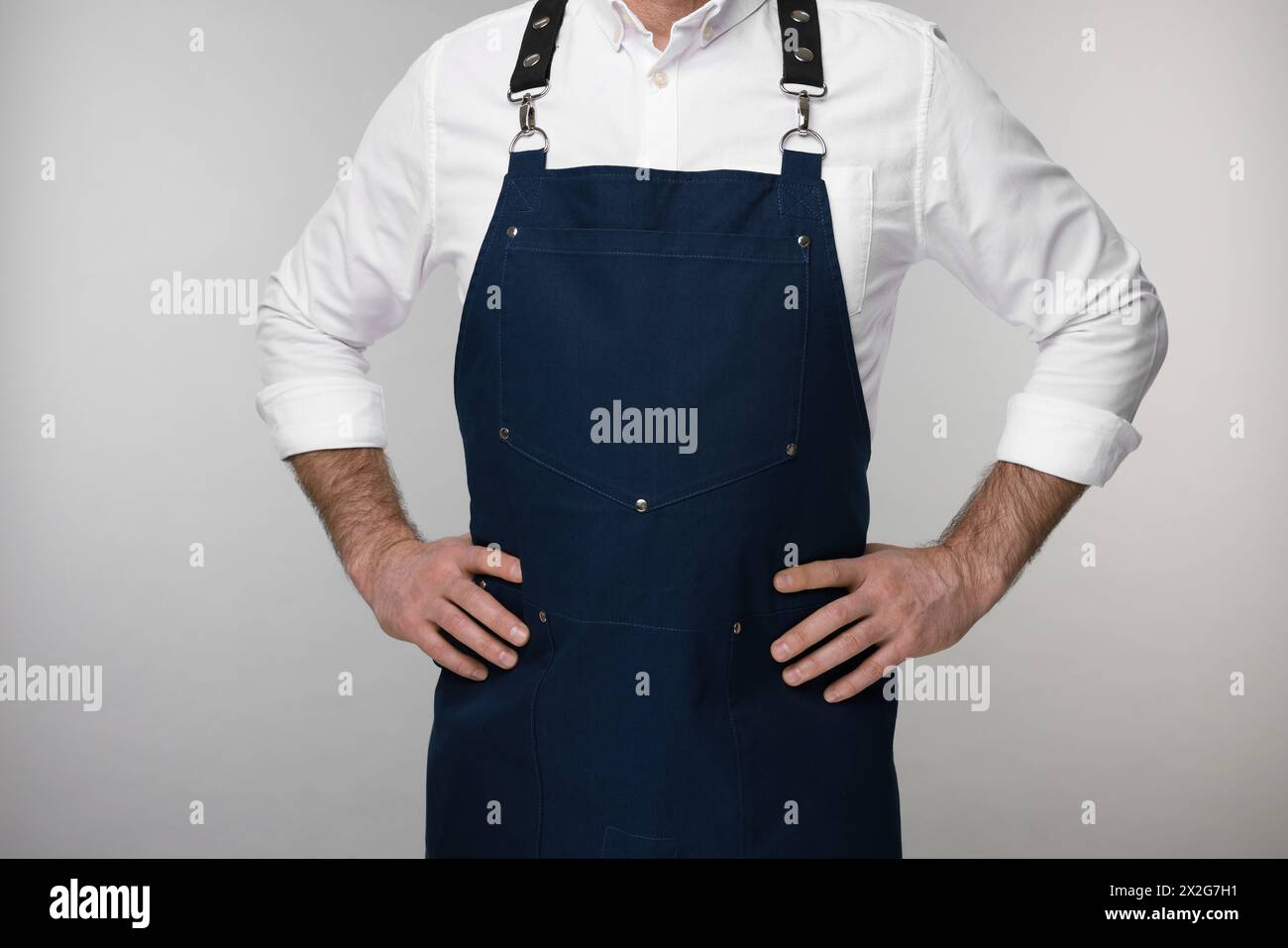 Man wearing kitchen apron on grey background, closeup. Mockup for ...