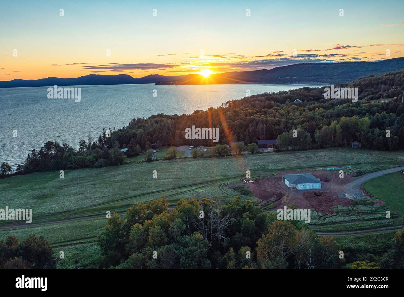 Sun rays of sunset from behind mountains near sea. Nice sunset scene ...