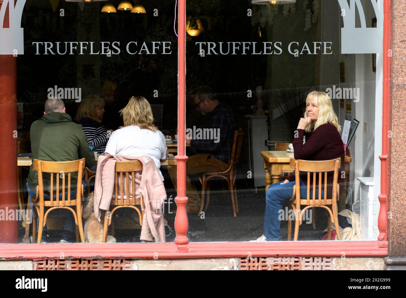 Woman sitting in a café window Stock Photo - Alamy