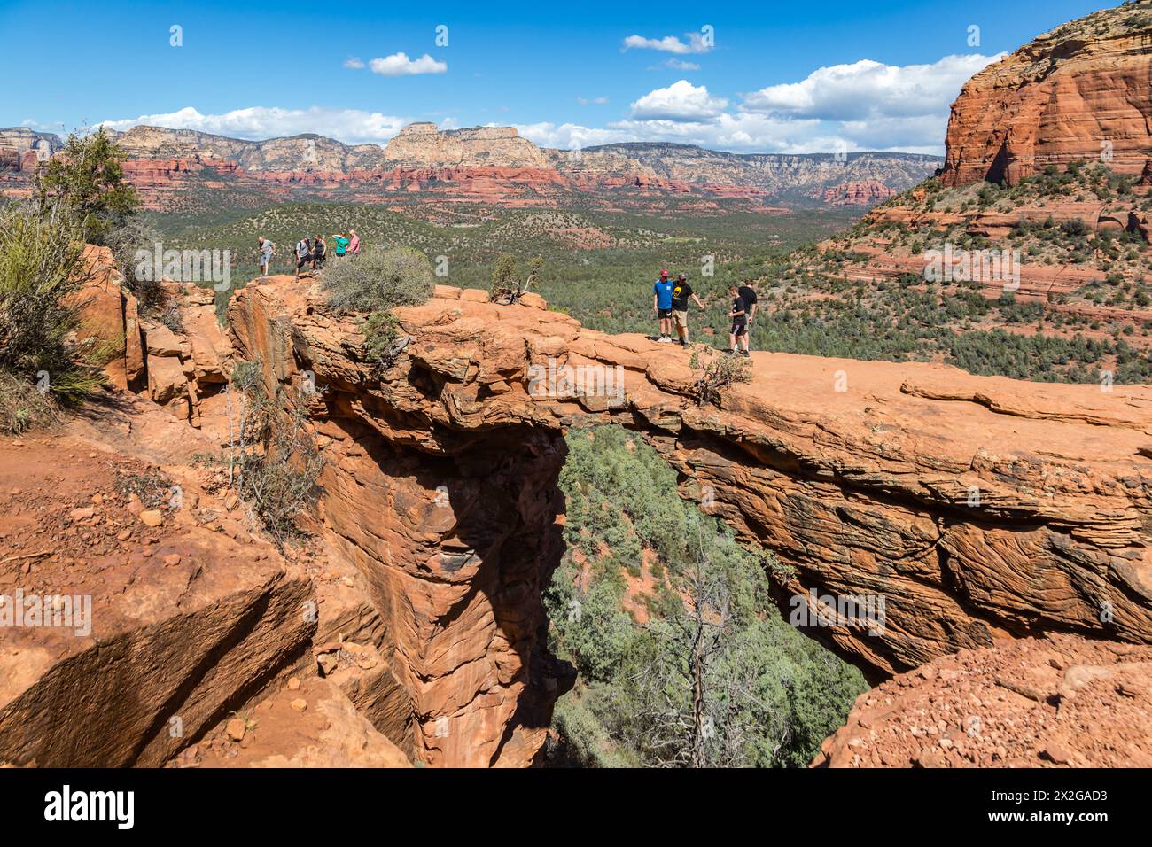 Hikers cross the Devil's Bridge natural arch along the Devil's Bridge ...
