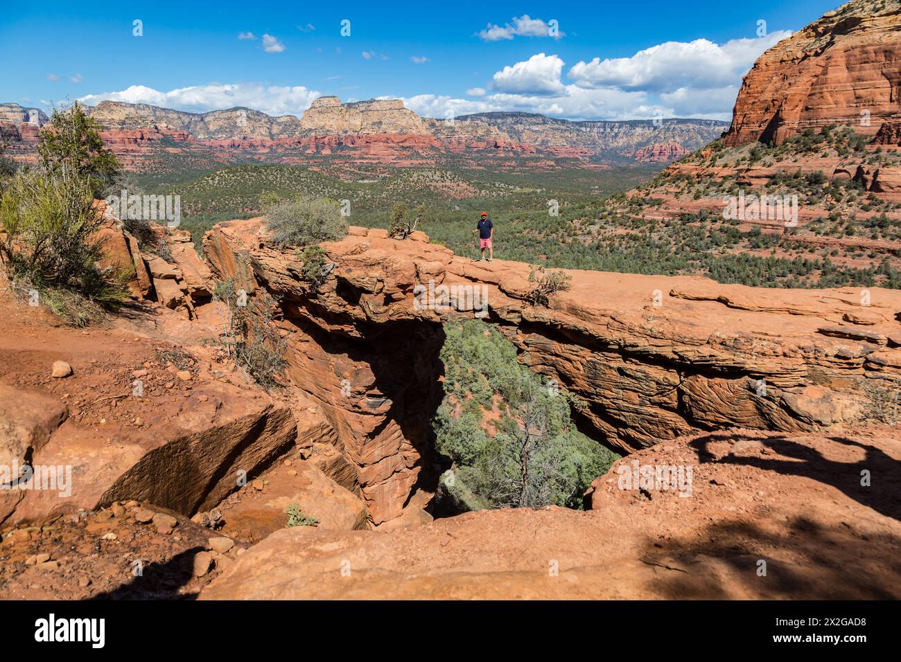 Hiker poses for pictures on the Devil's Bridge natural arch along the ...