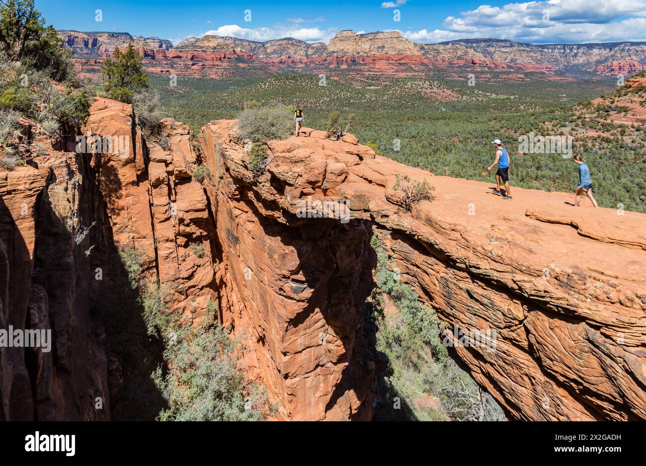 Hikers cross the Devil's Bridge natural arch along the Devil's Bridge ...