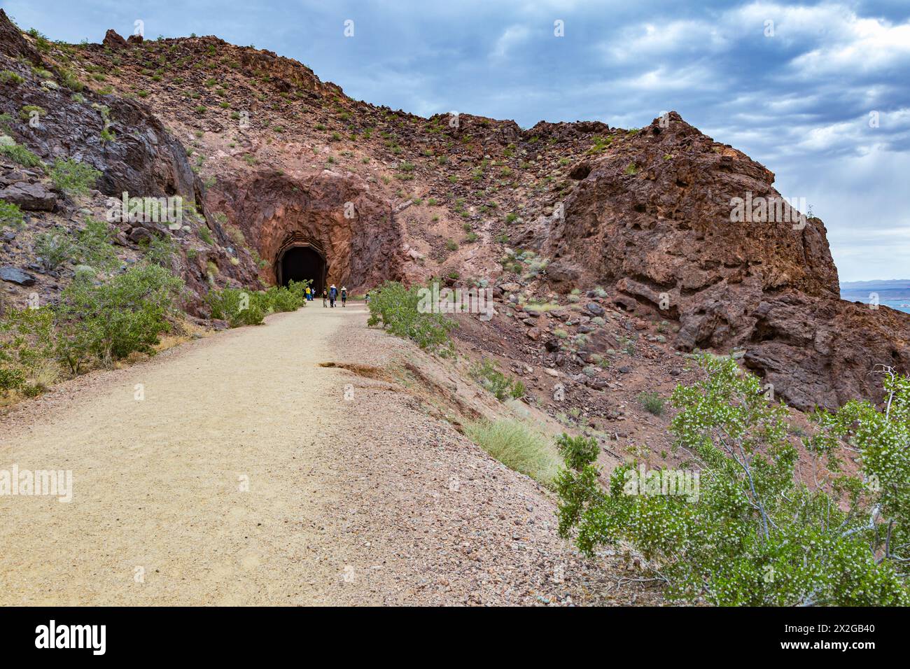Visitors walking near a tunnel opening along the Historic Railroad ...