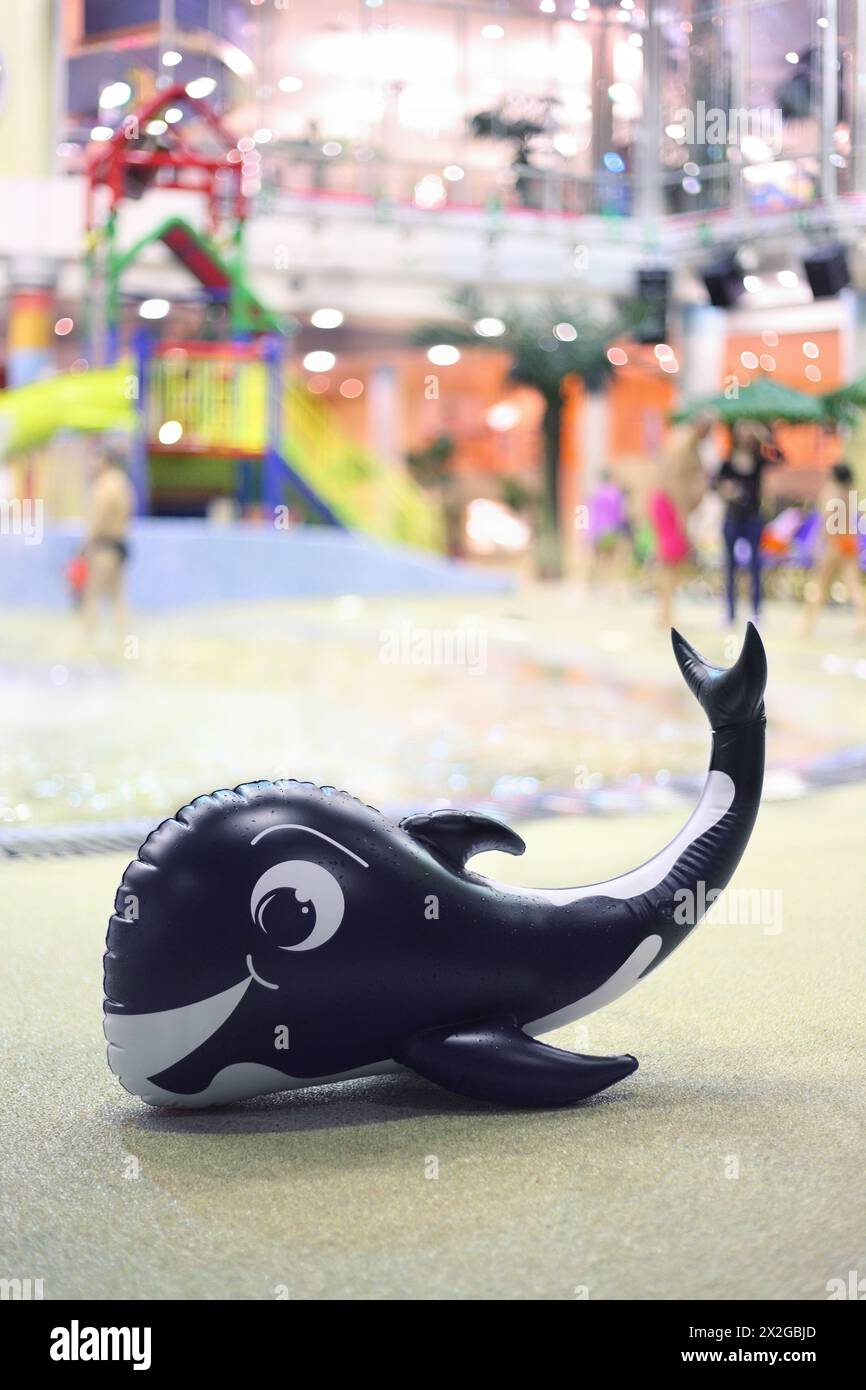 One amusing inflatable whale from rubber lies in water park near pool ...