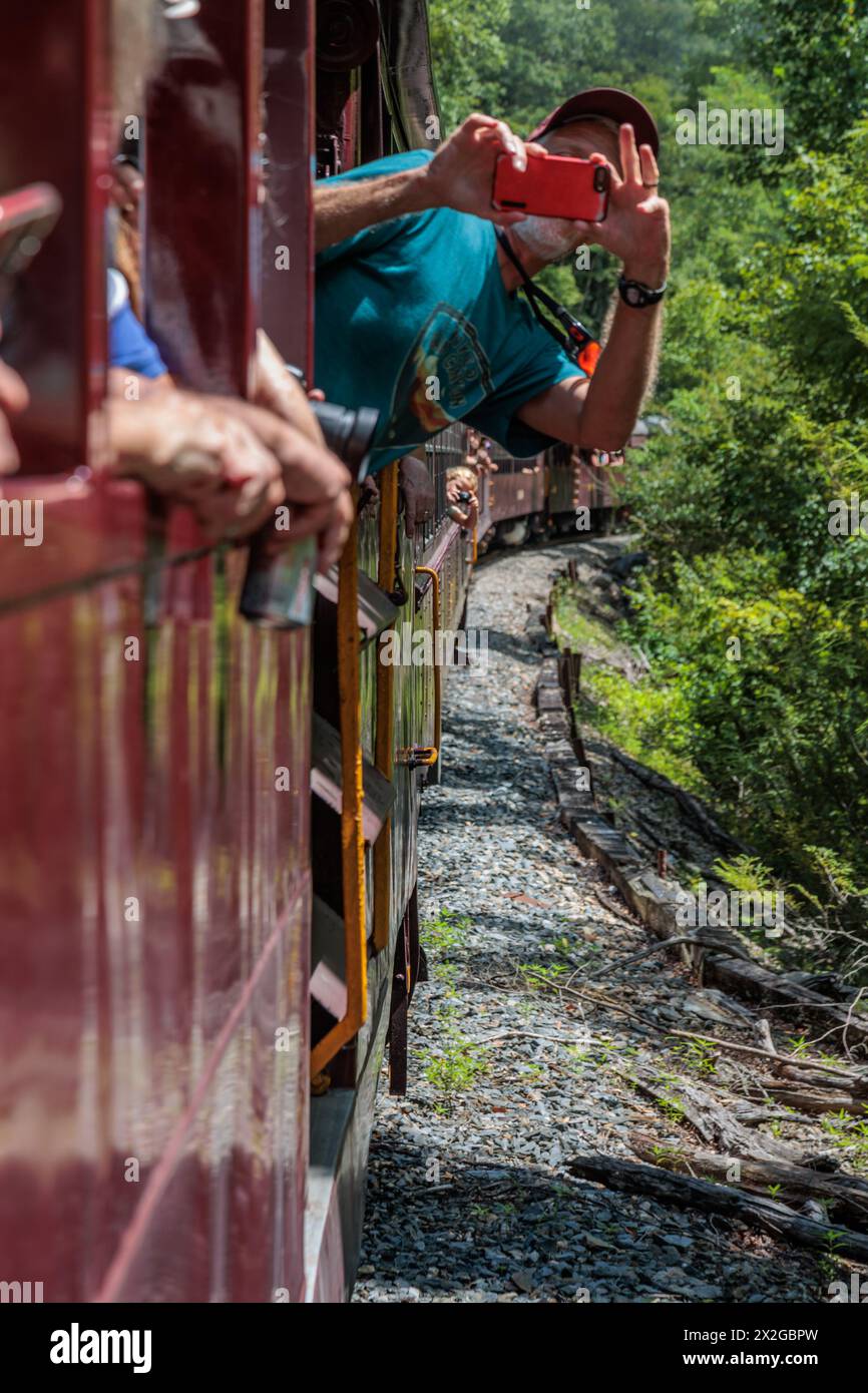 Man leaning out of the window of an open air train car of the Great ...