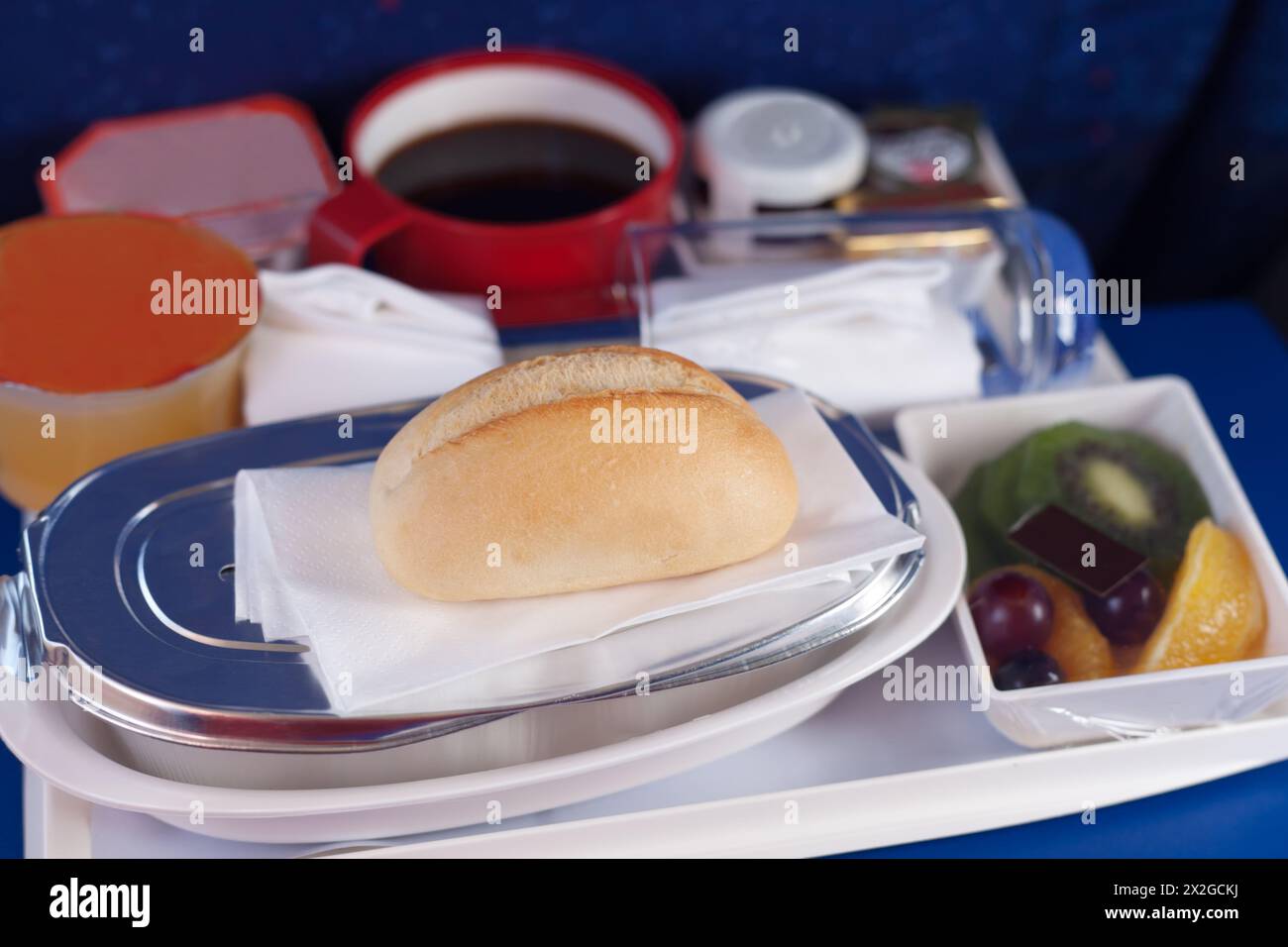 Tray of food on the plane. Focus on a bun Stock Photo - Alamy