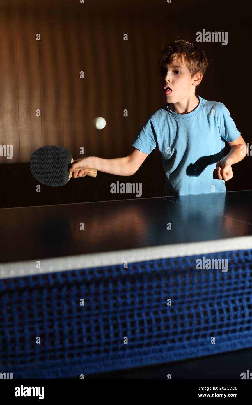 little boy playing ping pong; concentrated face; boy stuck out his tongue Stock Photo - Alamy