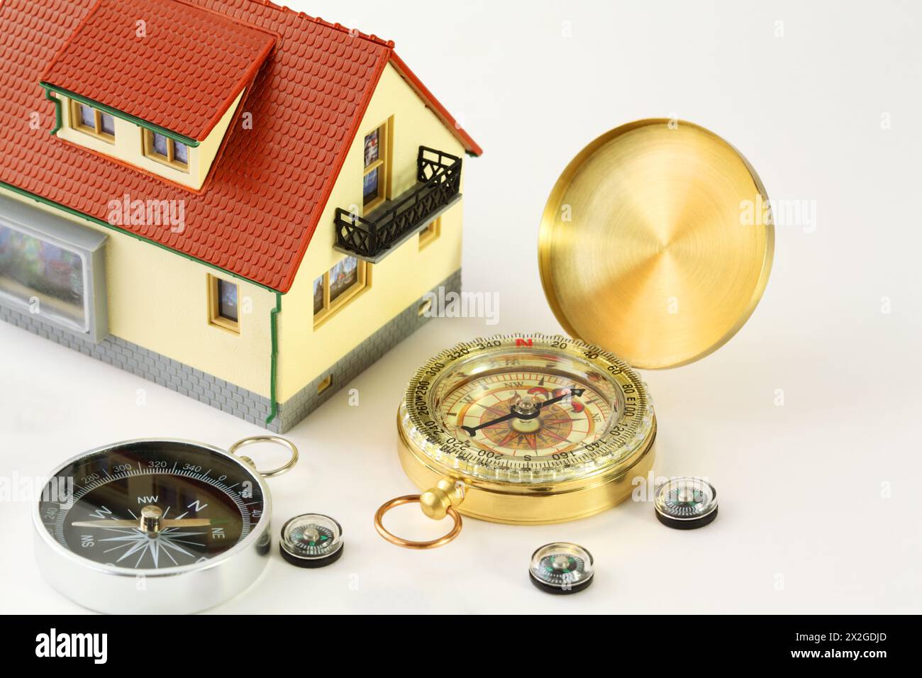 toy house with red roof and seven different compasses isolated on white ...