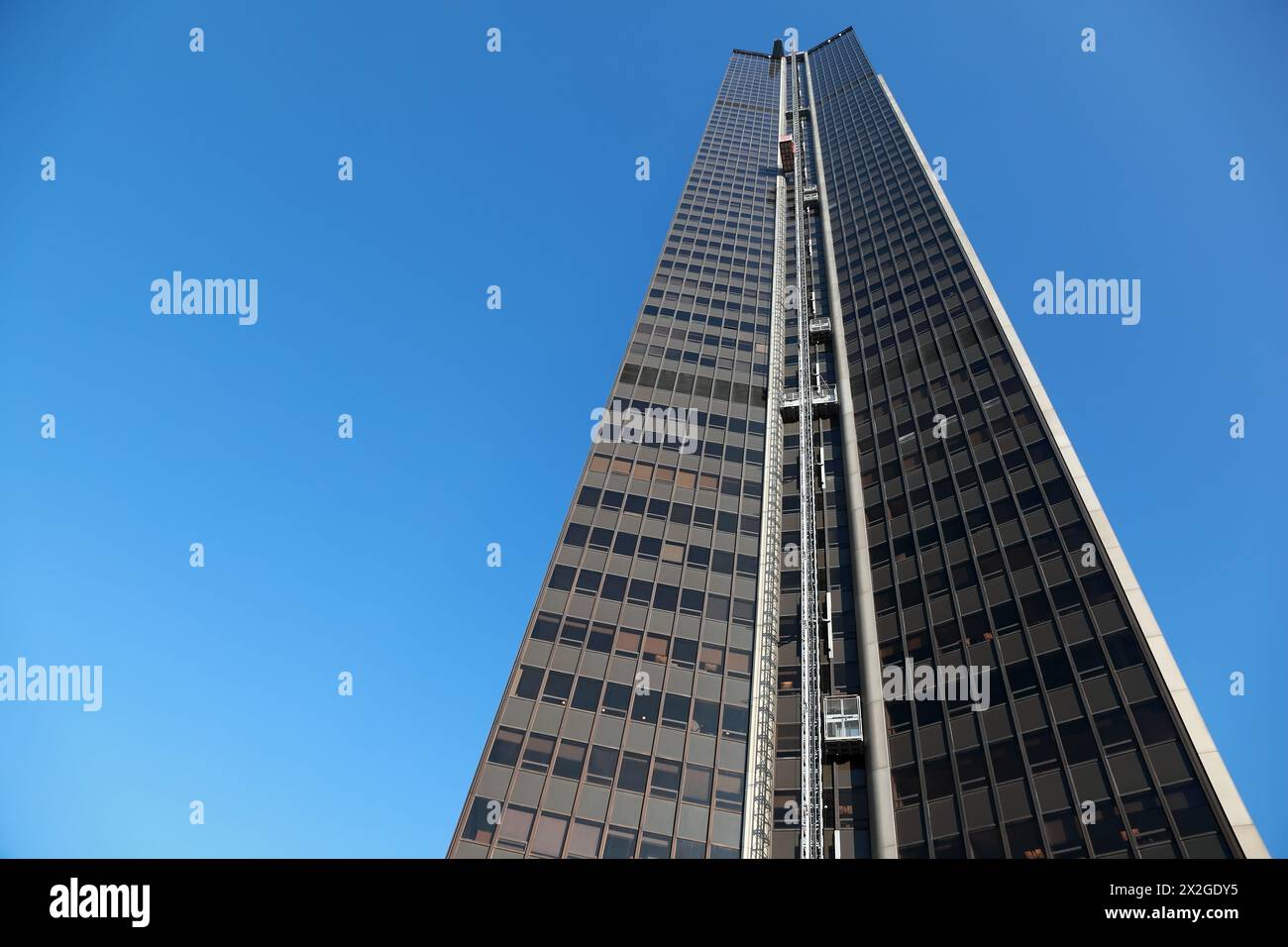 big, tall skyscraper with lifts, blue sky, many windows, Business ...