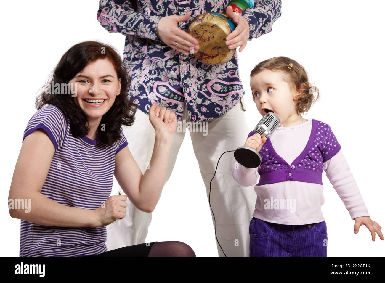 Father plays on the djembe, daughter sings into microphone and mother ...