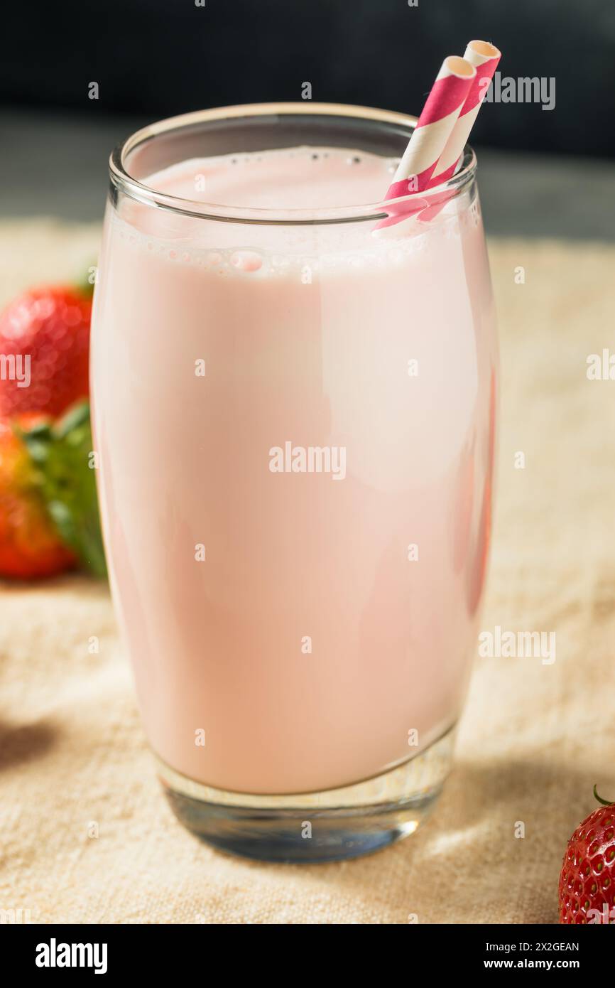 Healthy Pink Strawberry Milk in a Glass with a Straw Stock Photo - Alamy