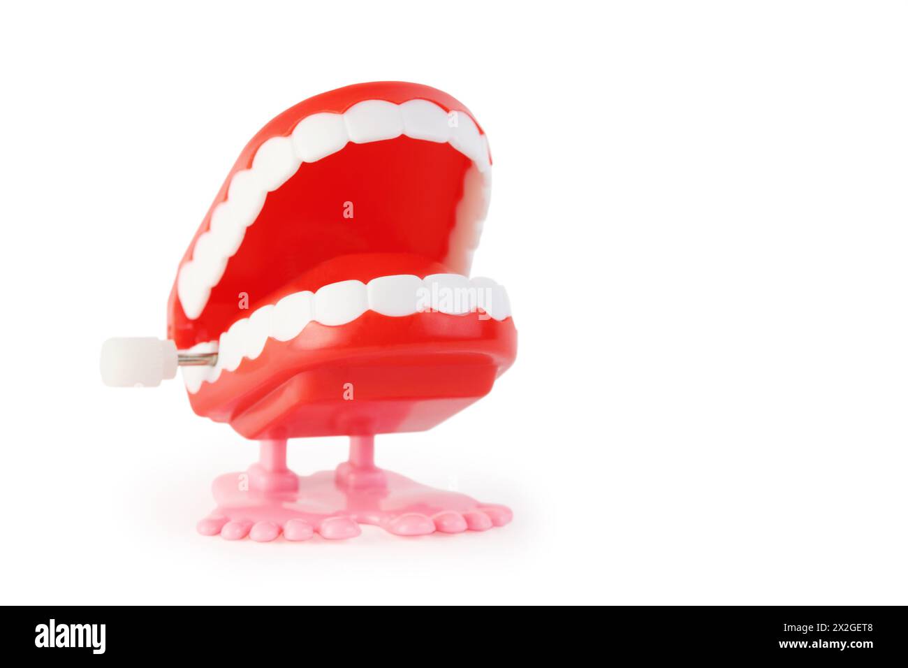 toy clockwork open jaw with white teeth on pink legs on white ...