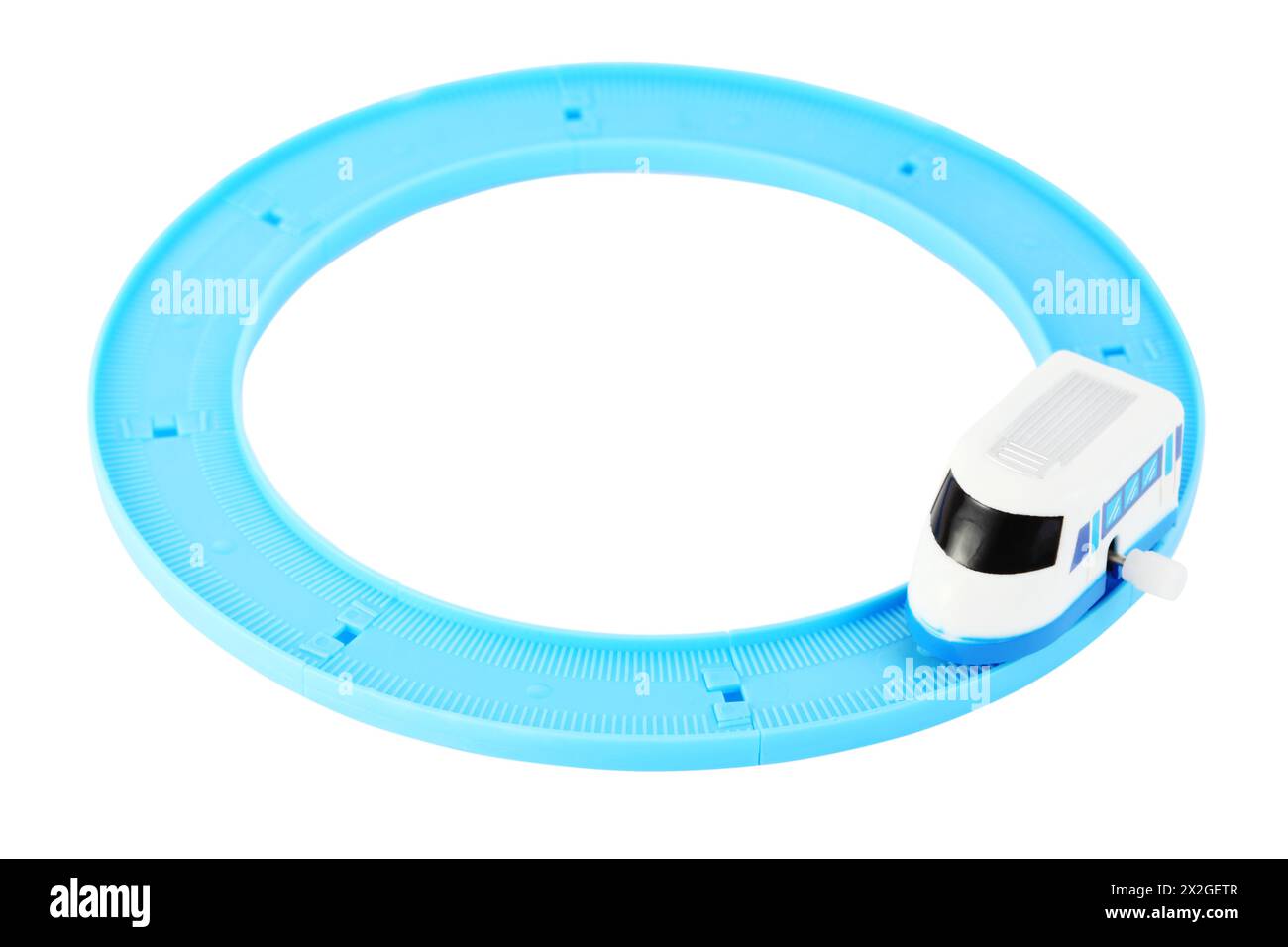 bright clockwork toy white train with blue windows on circular railroad ...