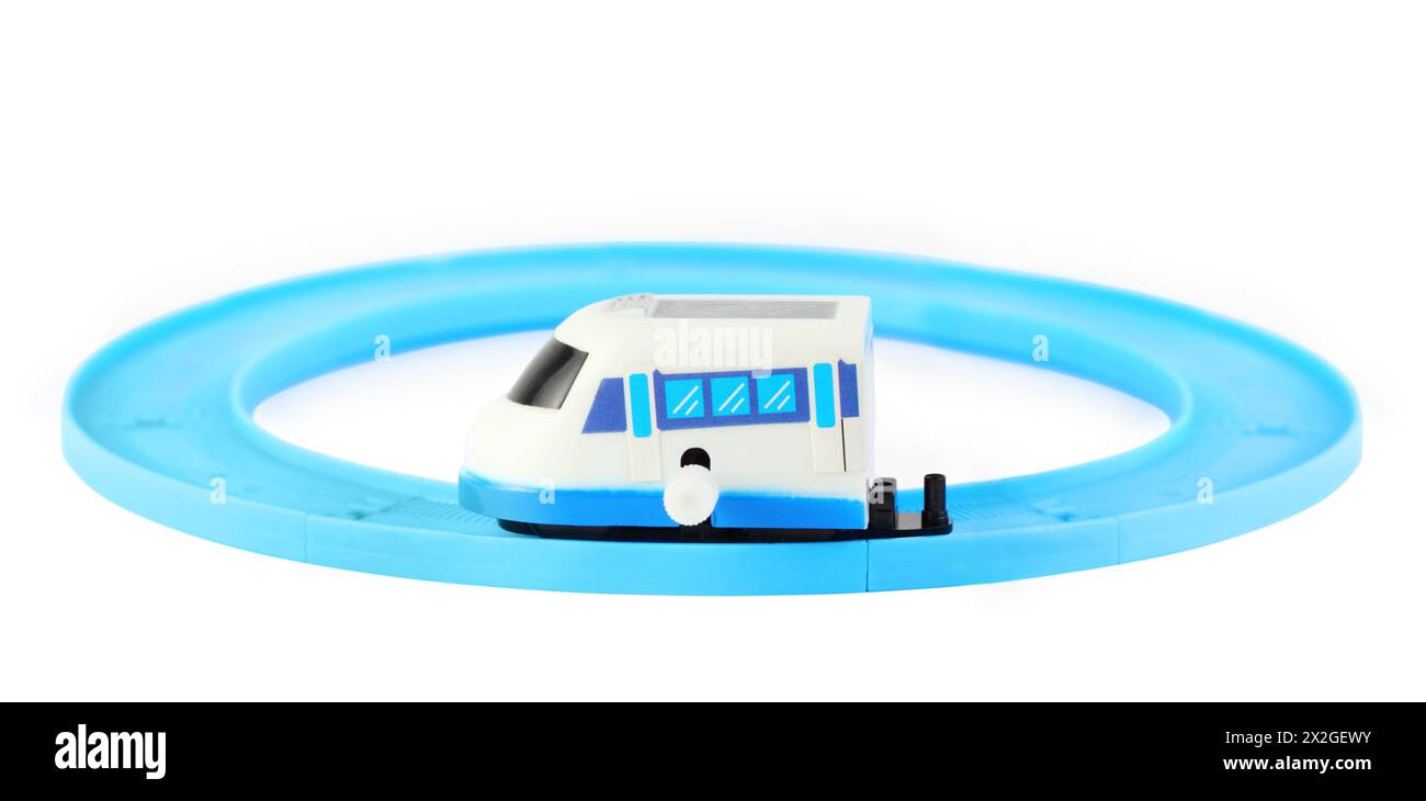 bright clockwork toy white train with blue windows on railroad on white ...