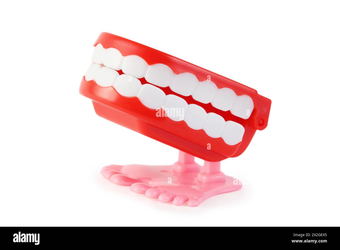 side view of bright toy clockwork jaw with white teeth on pink legs on ...