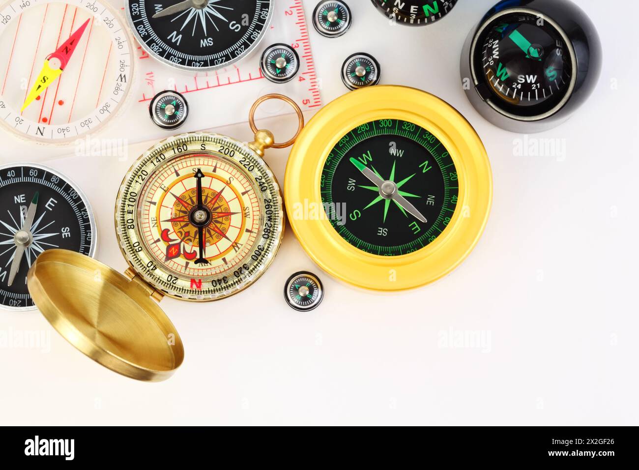 group of twelve different small and big compasses on white background ...