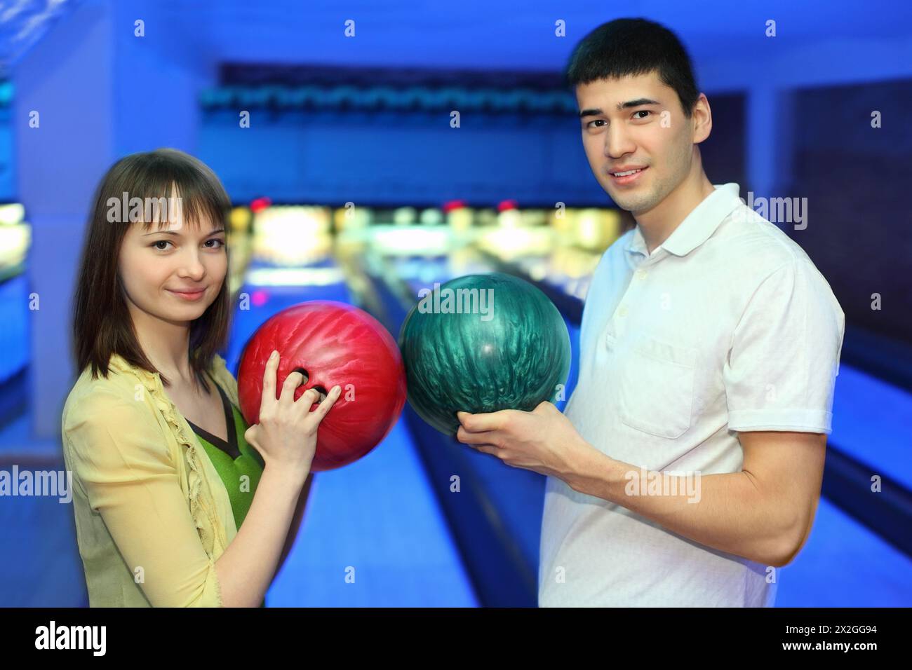 Girl and youth turned to each other and adjoin balls for bowling Stock ...