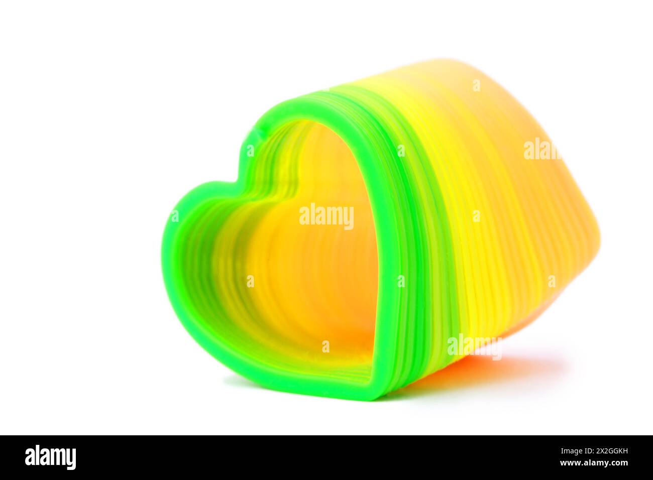 Plastic toy spring in heart-shaped, yellow and green colours Stock ...
