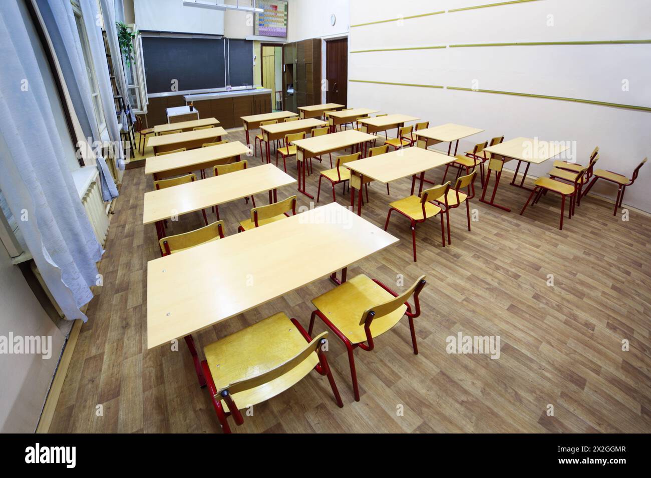 Back view of chairs in physics school class; blackboard with formula ...