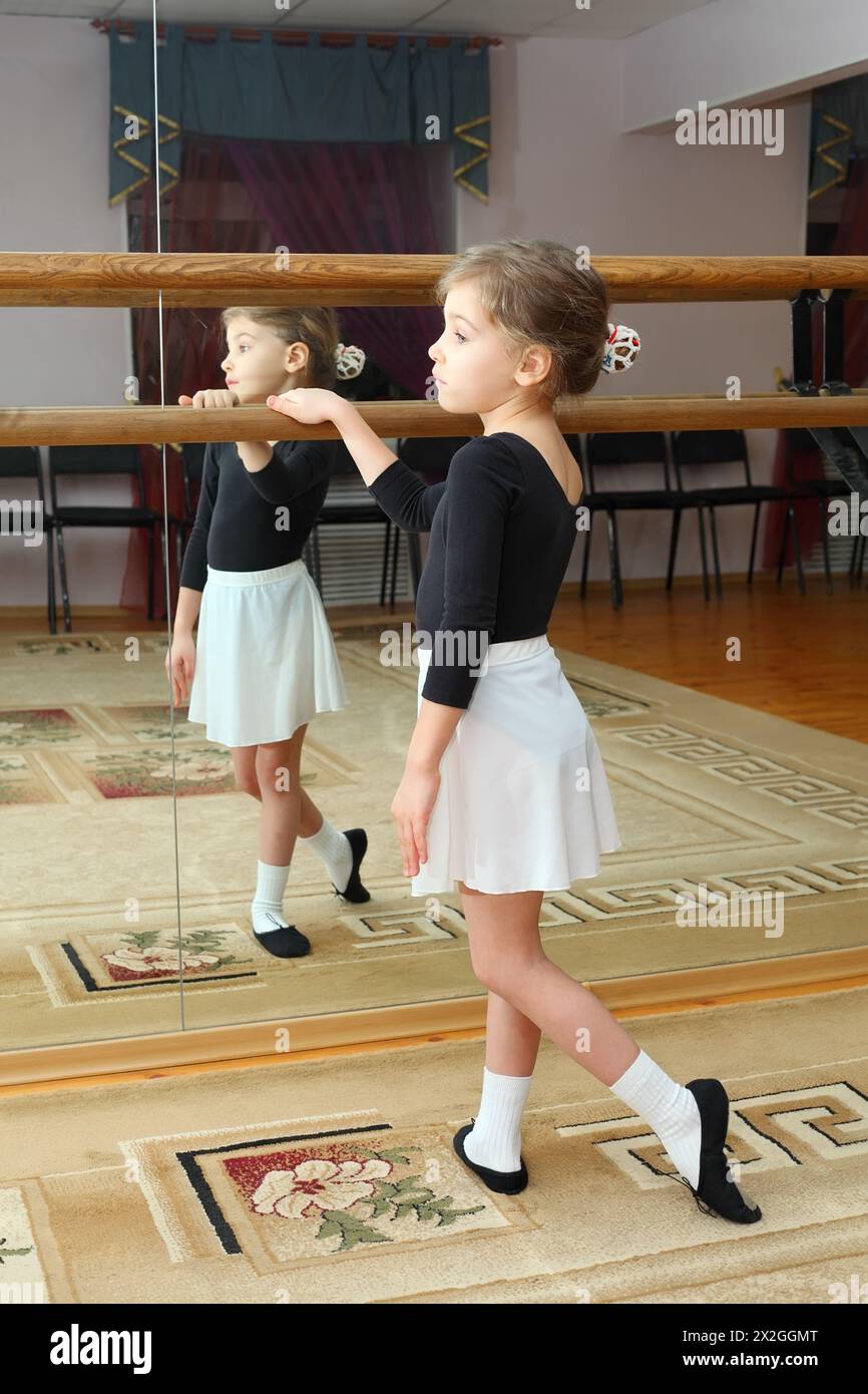 little girl wear pointe trains in ballet class near frame and large ...