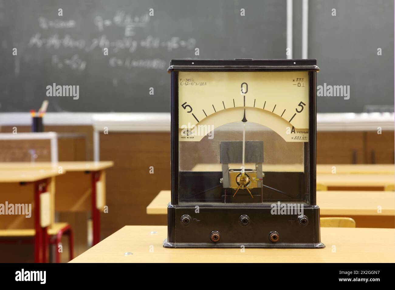Educational galvanometer with not real number 555 on yellow desk in ... Educational galvanometer with not real number 555 on yellow desk in ...