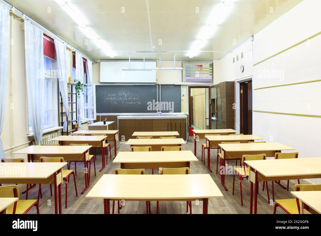 Back view of chairs in physics school class; blackboard with formula ...