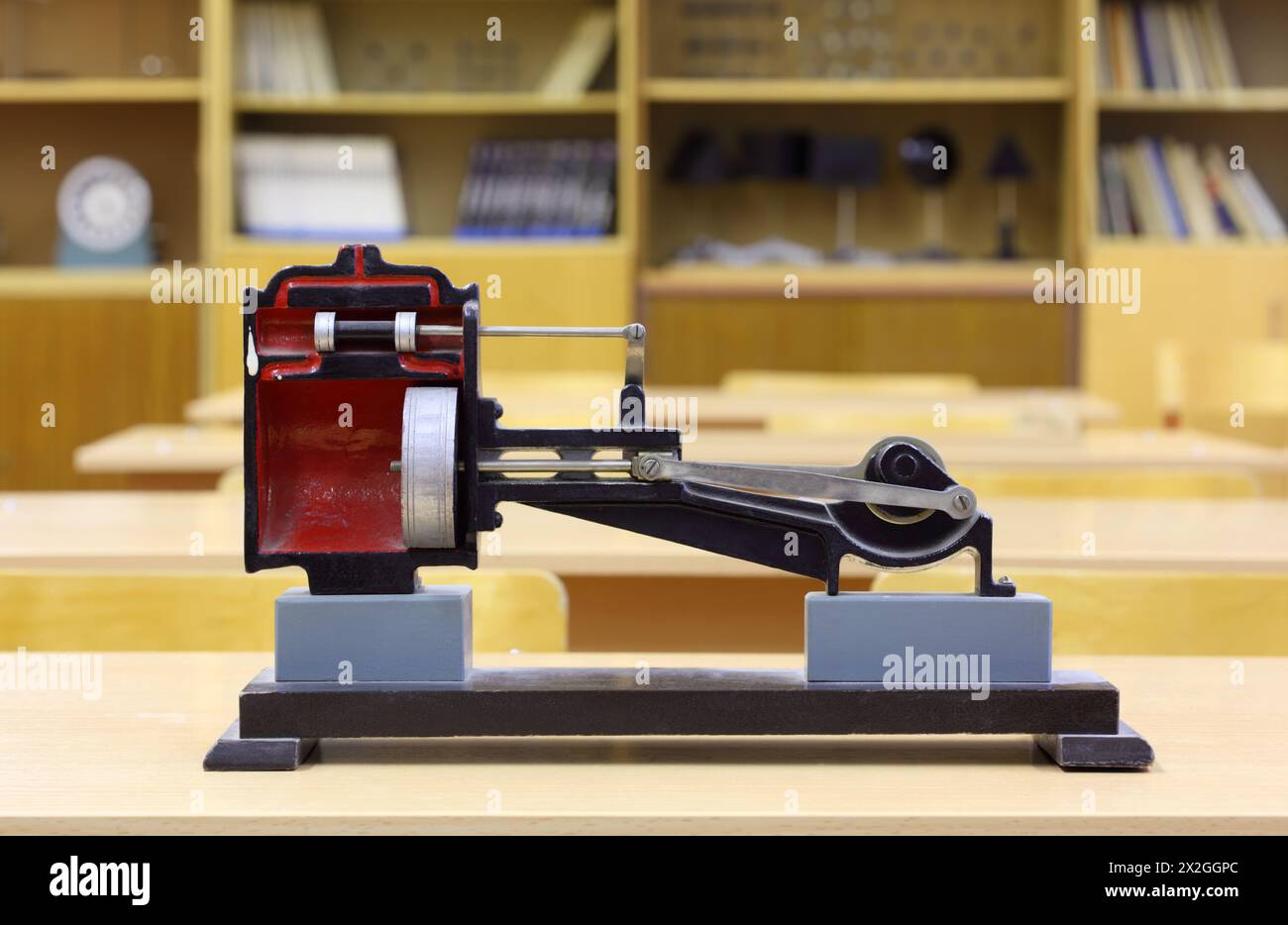 Model of steam engine on yellow desk in empty physics school class ...