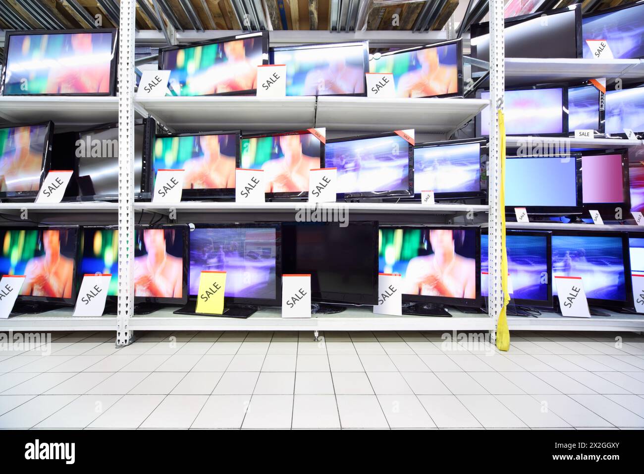 Plasma TVs with big diagonal stand on shelves in large shop; wide range ...