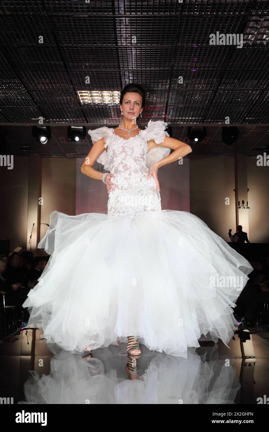 Beautiful model wear wedding dress walks catwalk at evening podium ...