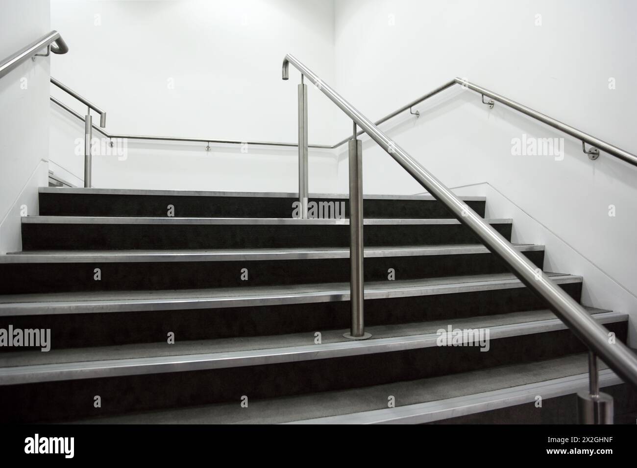 wide staircase with chrome handrails and gray steps, white walls Stock ...
