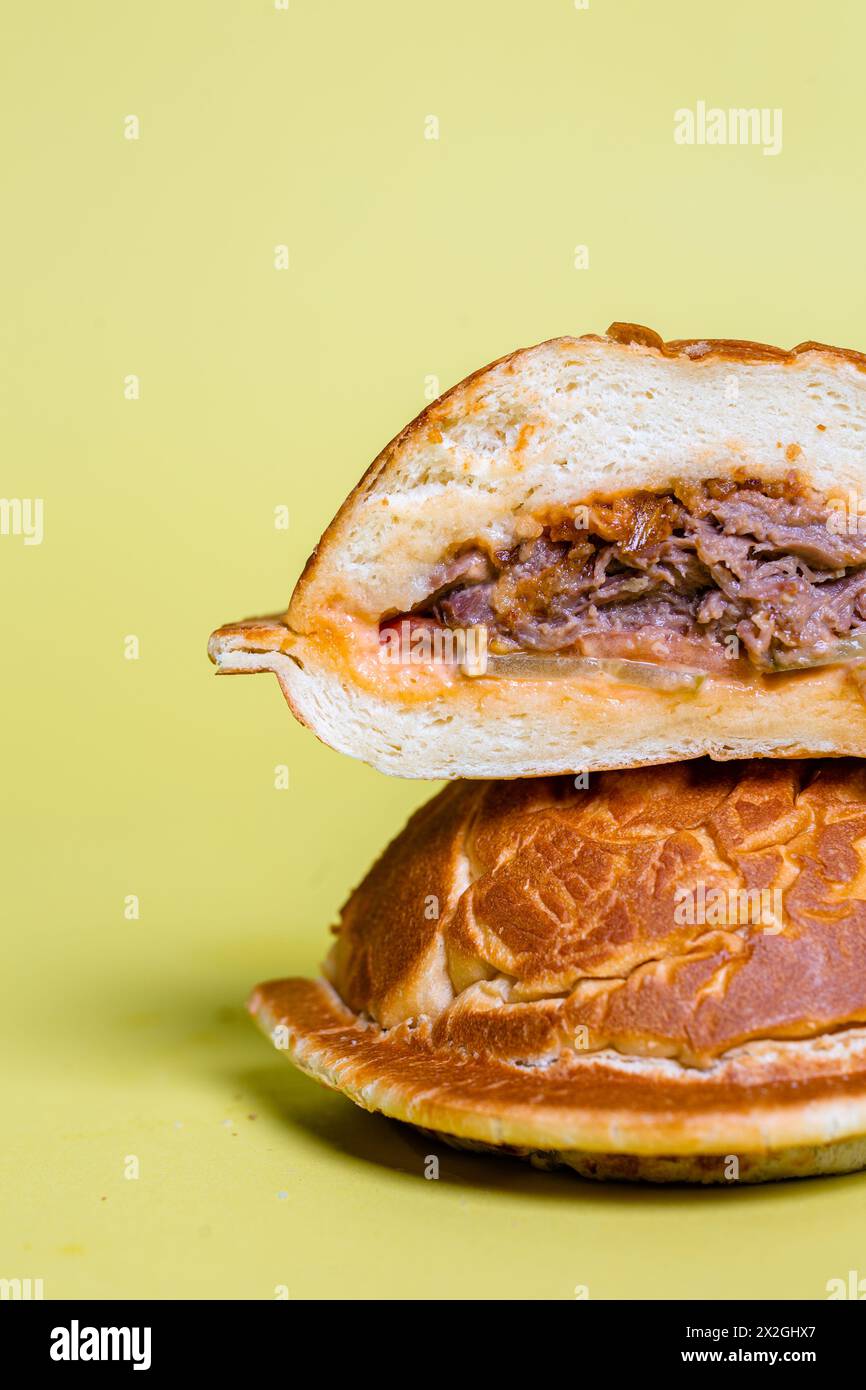 juicy burger cut with delicious filling on a yellow background Stock ...