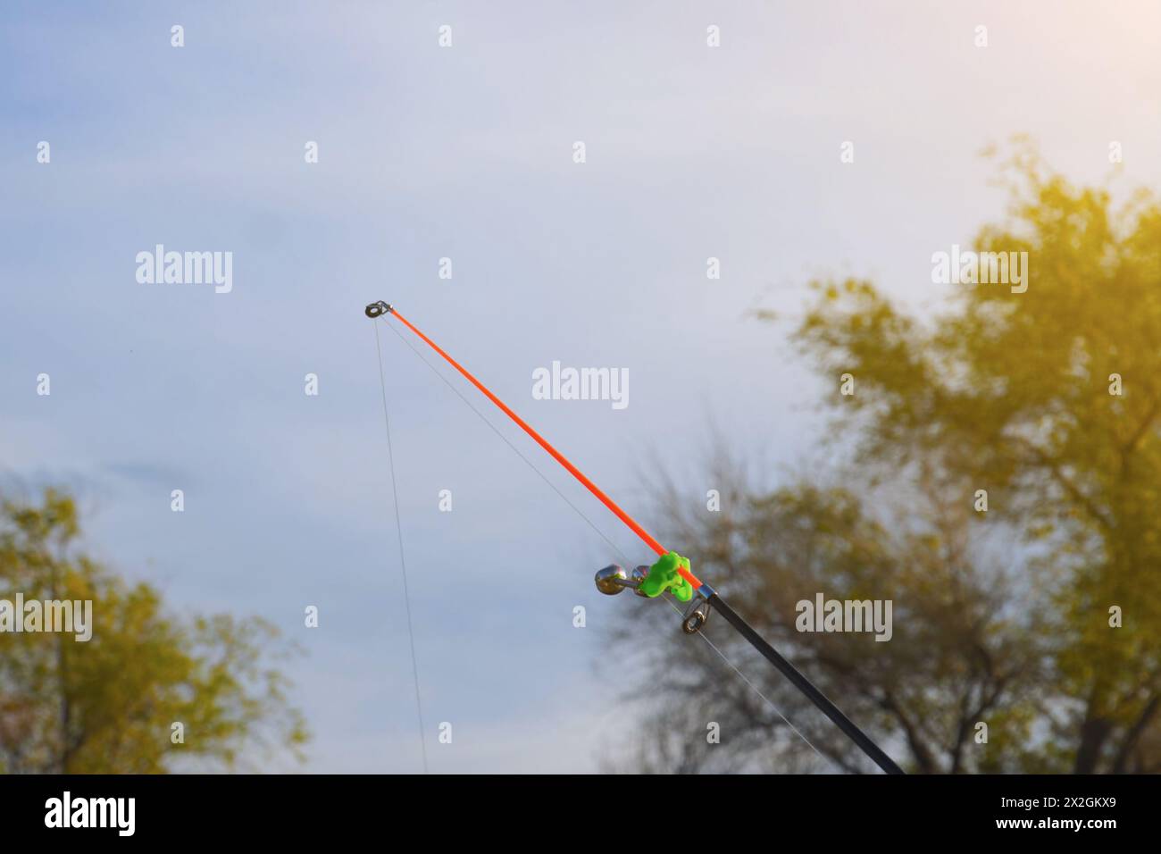 The tip of a fishing rod with a bell on the sky background Stock Photo ...
