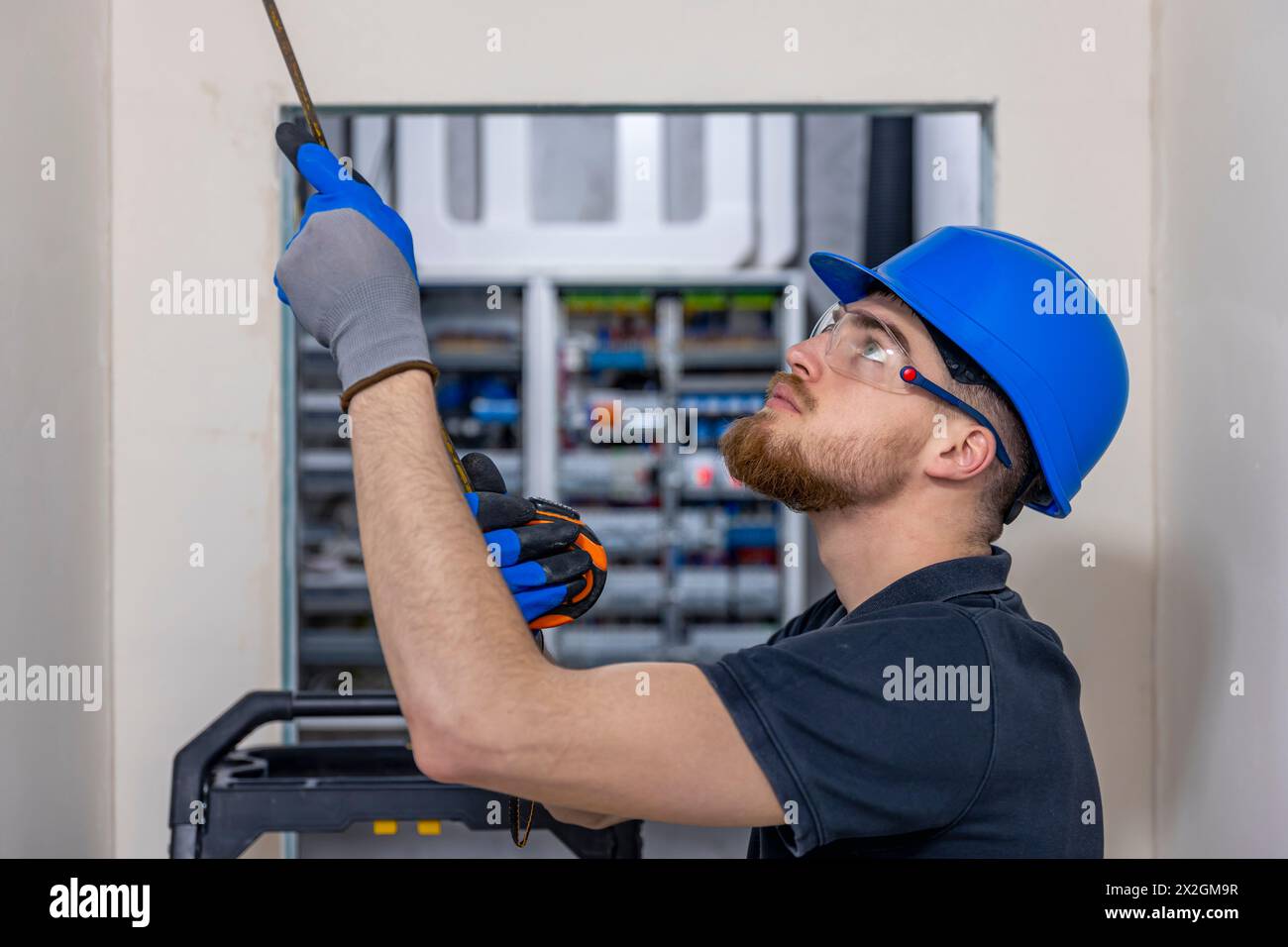 Electrician installing laying electrical cables on the ceiling inside ...